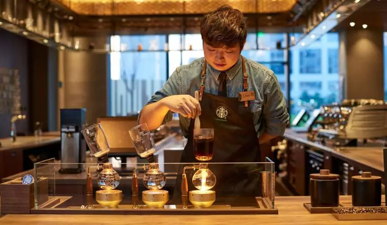 Barista frá Starbucks í Kína blandar saman drykk.