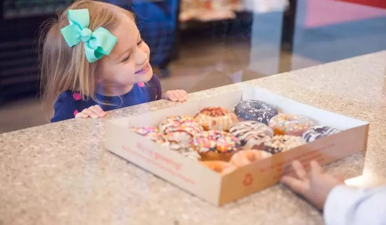 Seorang kanak-kanak memesan dari kaunter di Duck Donuts.