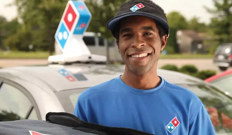 May hawak na pizza ang delivery driver ng Domino.