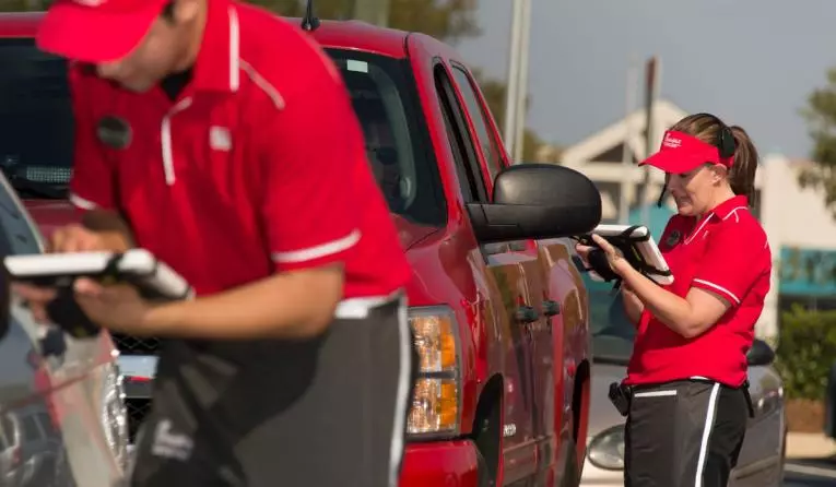 Punëtorët që marrin urdhra në makinën Chick-fil-A.