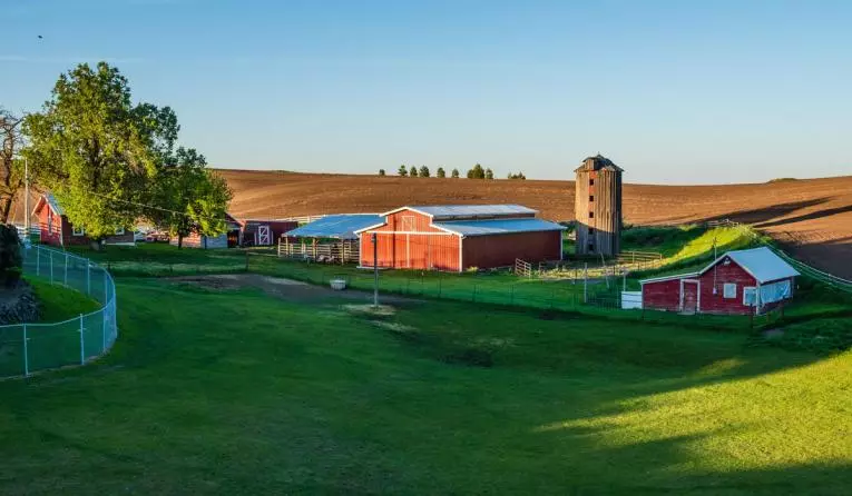 Napközben látott farm, piros pajtával.