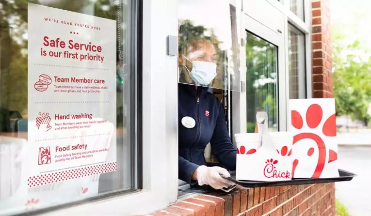 Chick-fil-Oynada ovqat tarqatayotgan xodim.