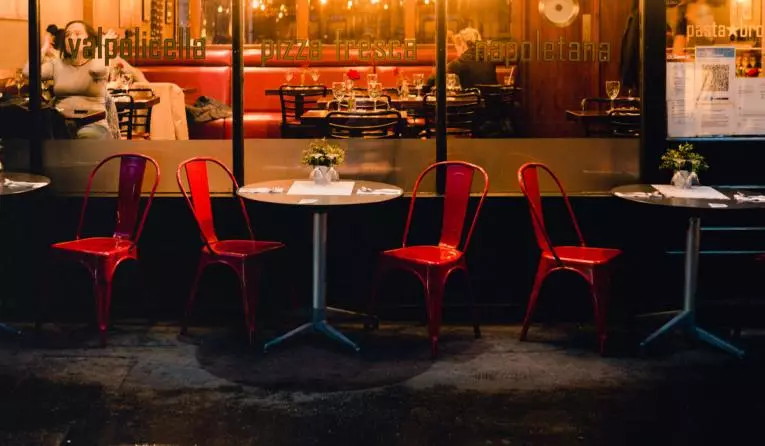 Červené stoličky pred reštauráciou v noci.
