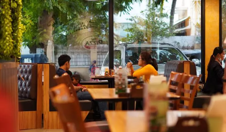 Els convidats s'asseuen a una taula dins d'un restaurant.