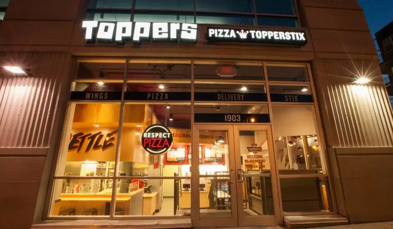Toppers Pizza restorāna priekšpuse naktī.