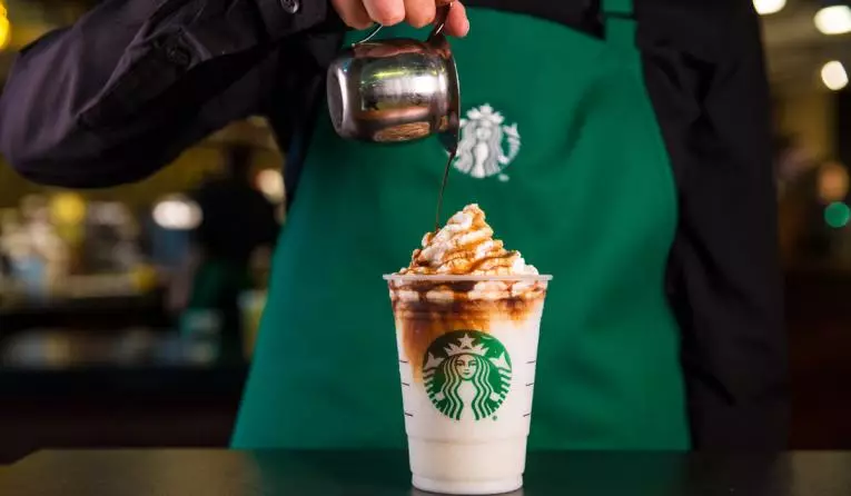 Barista Starbucksa wlewa espresso do drinka.