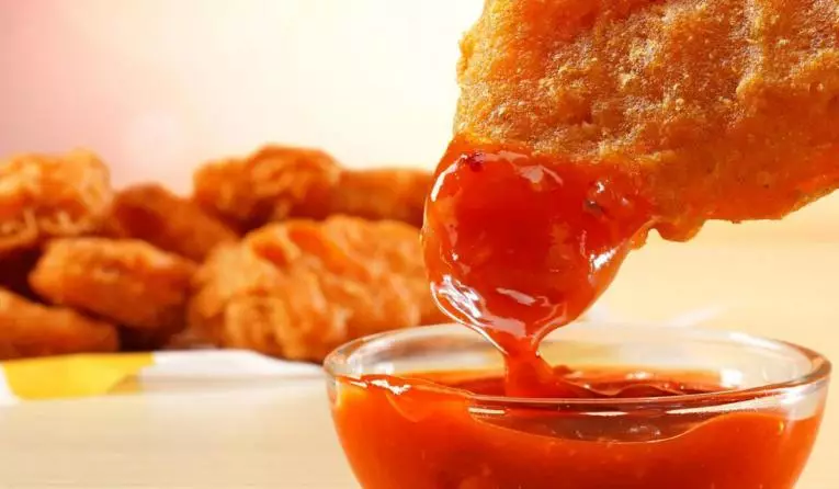 Les pépites de poulet épicées de McDonald's sont trempées dans la sauce.