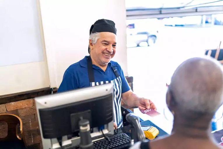 Anzjan jagħti lil klijent karta fil-cash register.