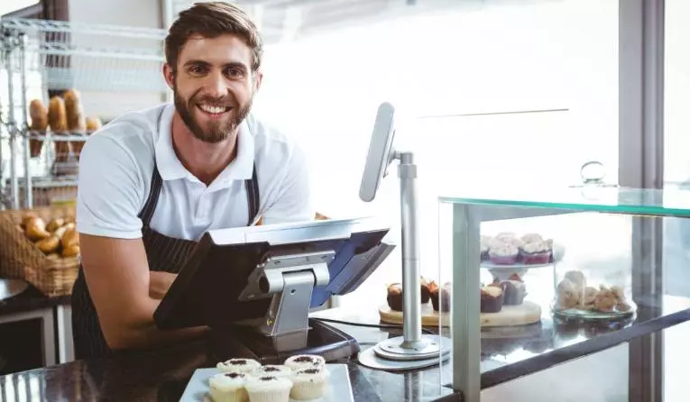 Smilende restaurantmedarbejder bag disken.