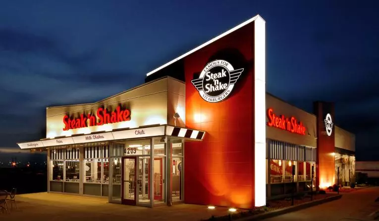 Eksterijer restorana Steak 'n Shake osvijetljen je noću.